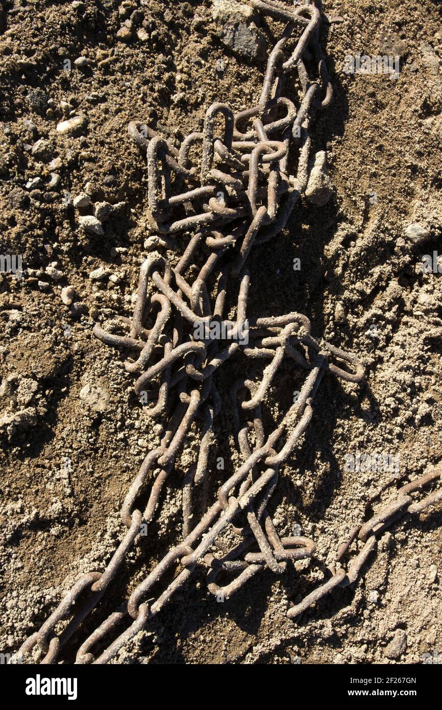 A vertical shot of old and rustic chains on a sandy beach Stock Photo ...