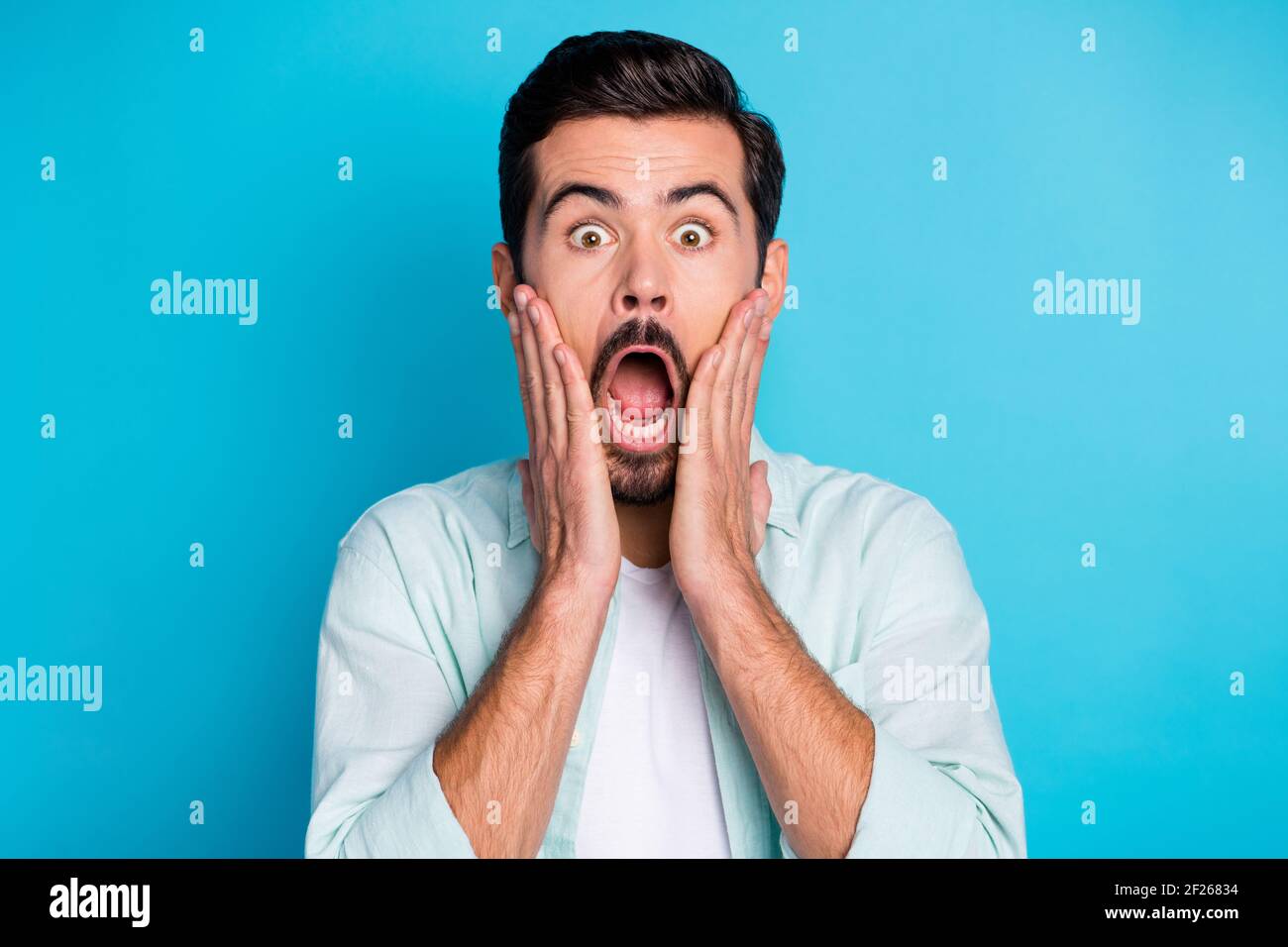 Photo of shocked impressed young guy wear casual shirt open mouth arms ...