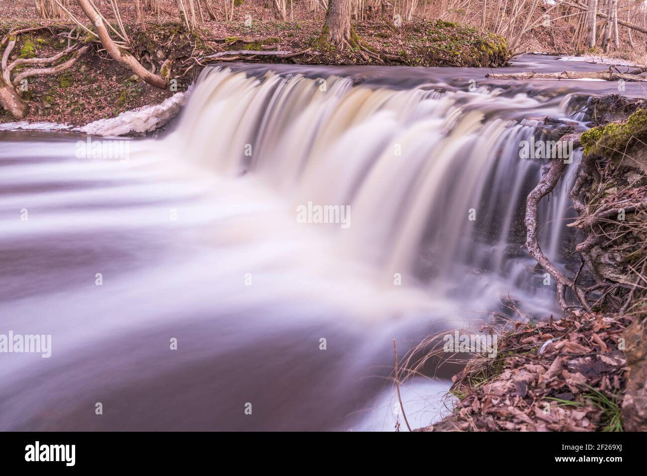 waterfall in several stages and fallen leaves brown but water flow in ...