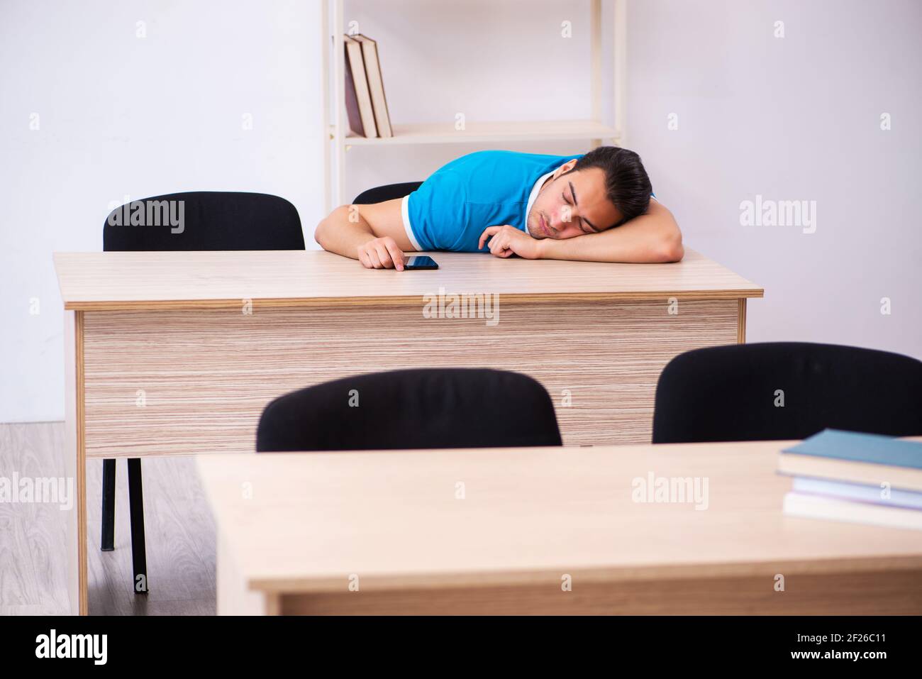 Exhausted male student preparing for the exams in the classroom Stock ...