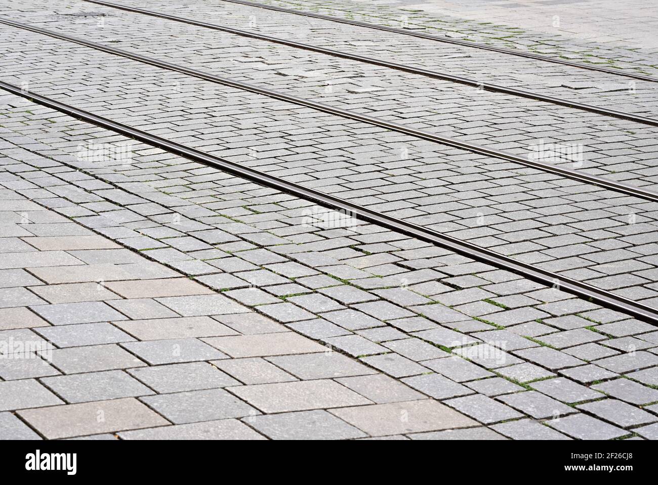Detail on steel tram rail tiled stone floor around Stock Photo - Alamy