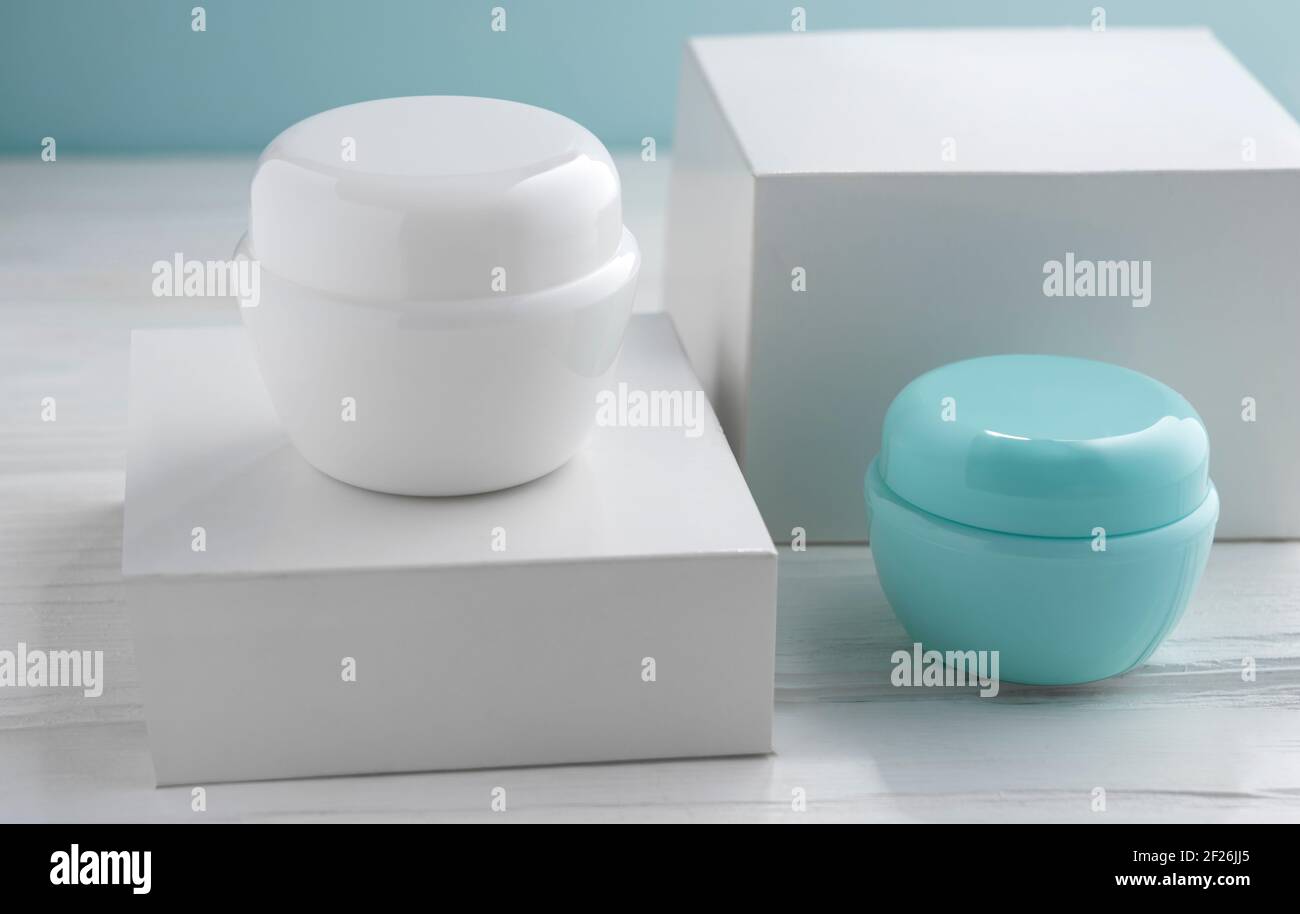Two white and blue cream containers and blank white box Stock Photo - Alamy
