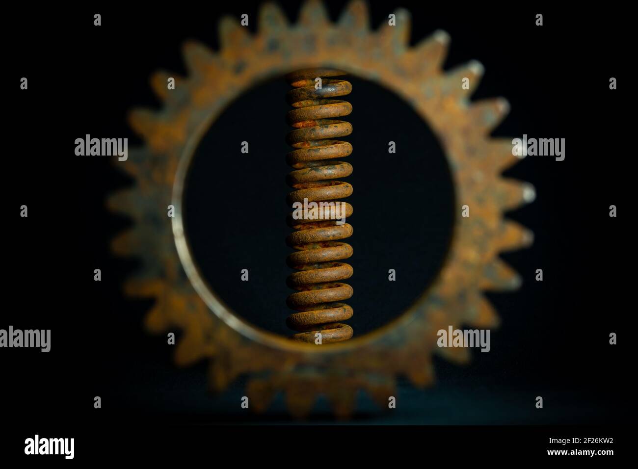 Old rusty spring and gear with black background Stock Photo - Alamy