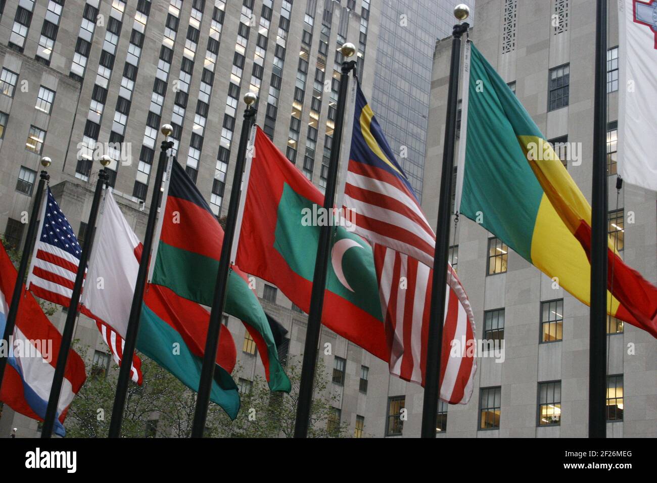 A low angle shot of flags of different countries in front of buildings ...