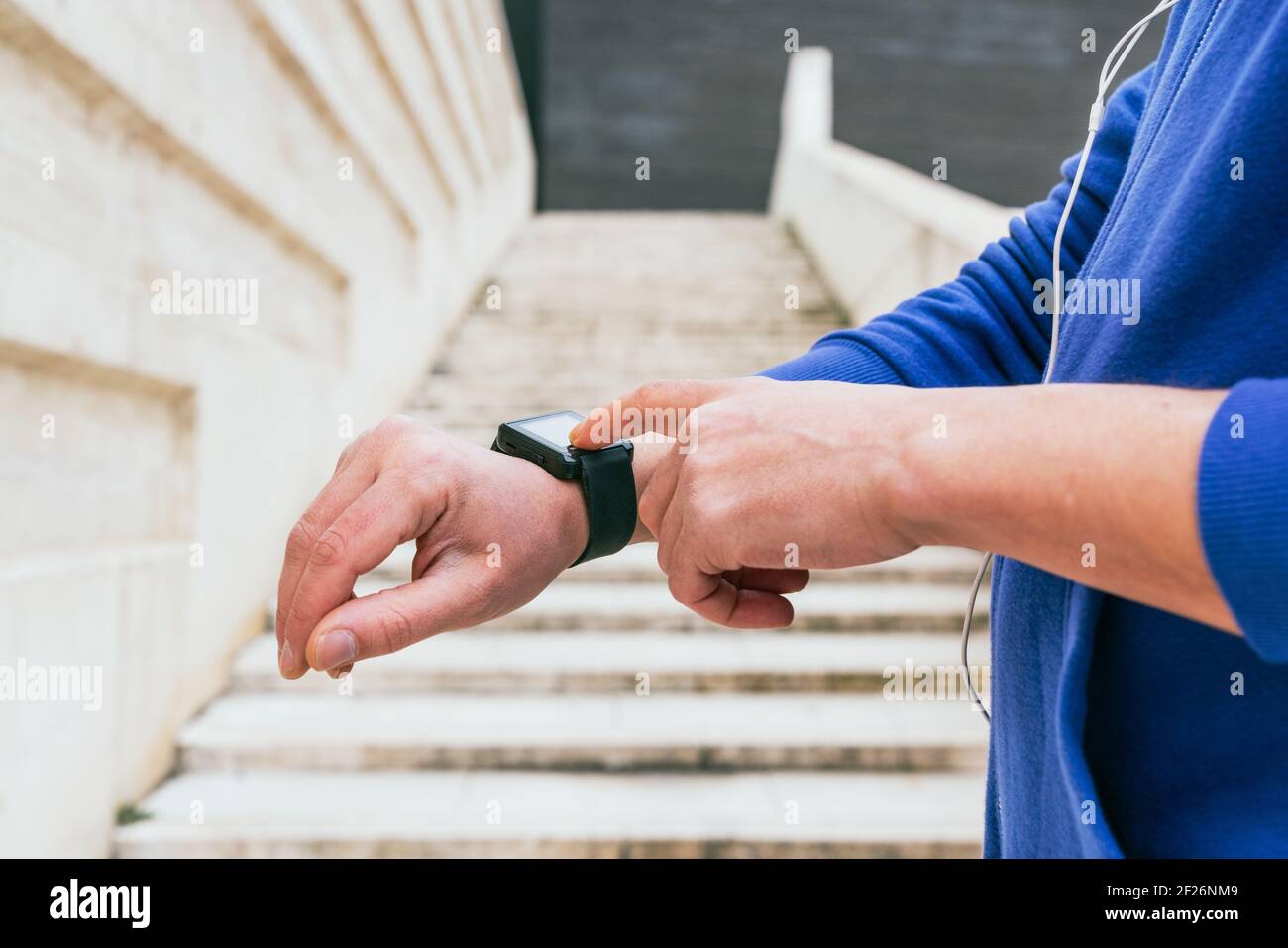 A male checking the smartwatch with a heartbeat monitor after running ...