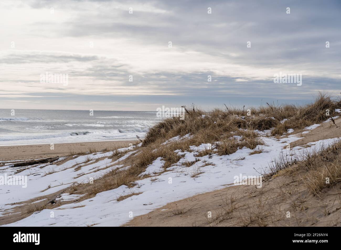 The beach in Montauk during the Winter, at sunset, with snow covering ...