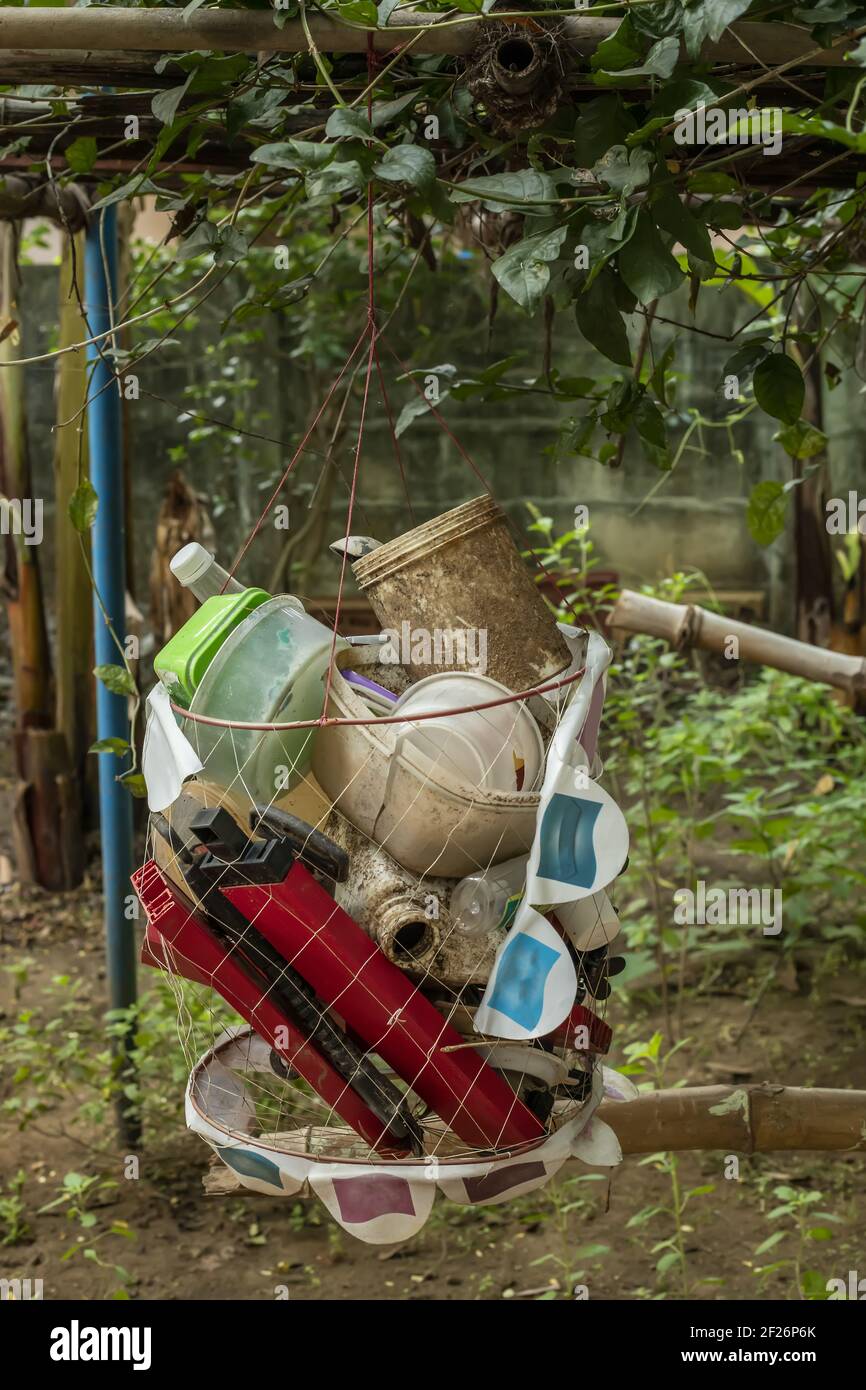 A vertical shot of random dirty pieces of plastic in a net hanging from ...