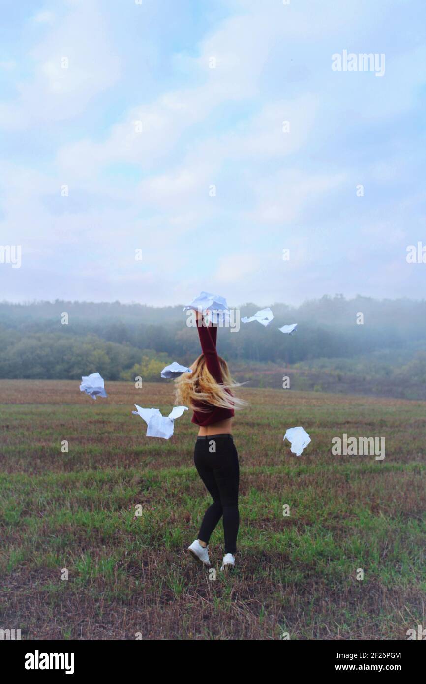 A girl throwing papers in the air Stock Photo - Alamy