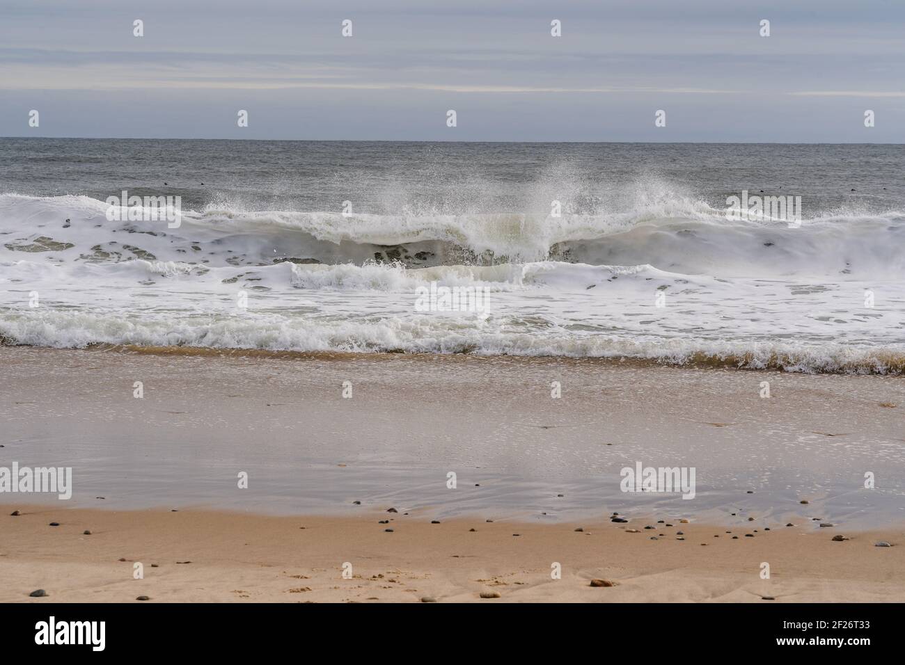 Waves crashing into the sand from a beach in Montauk at sunset Stock ...