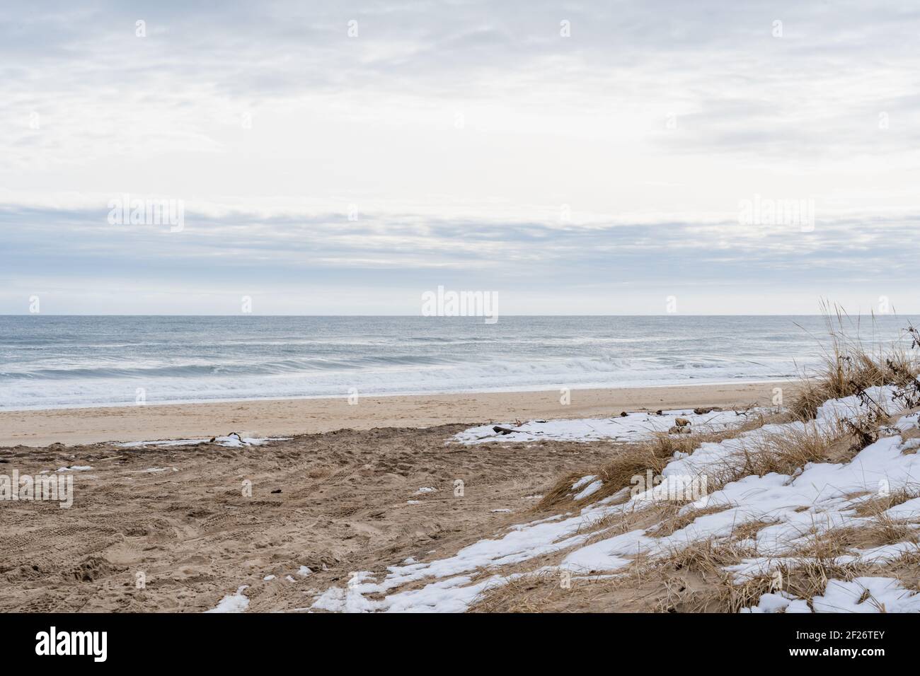 View of waves crashing into the beach at sunset, during the winter with ...