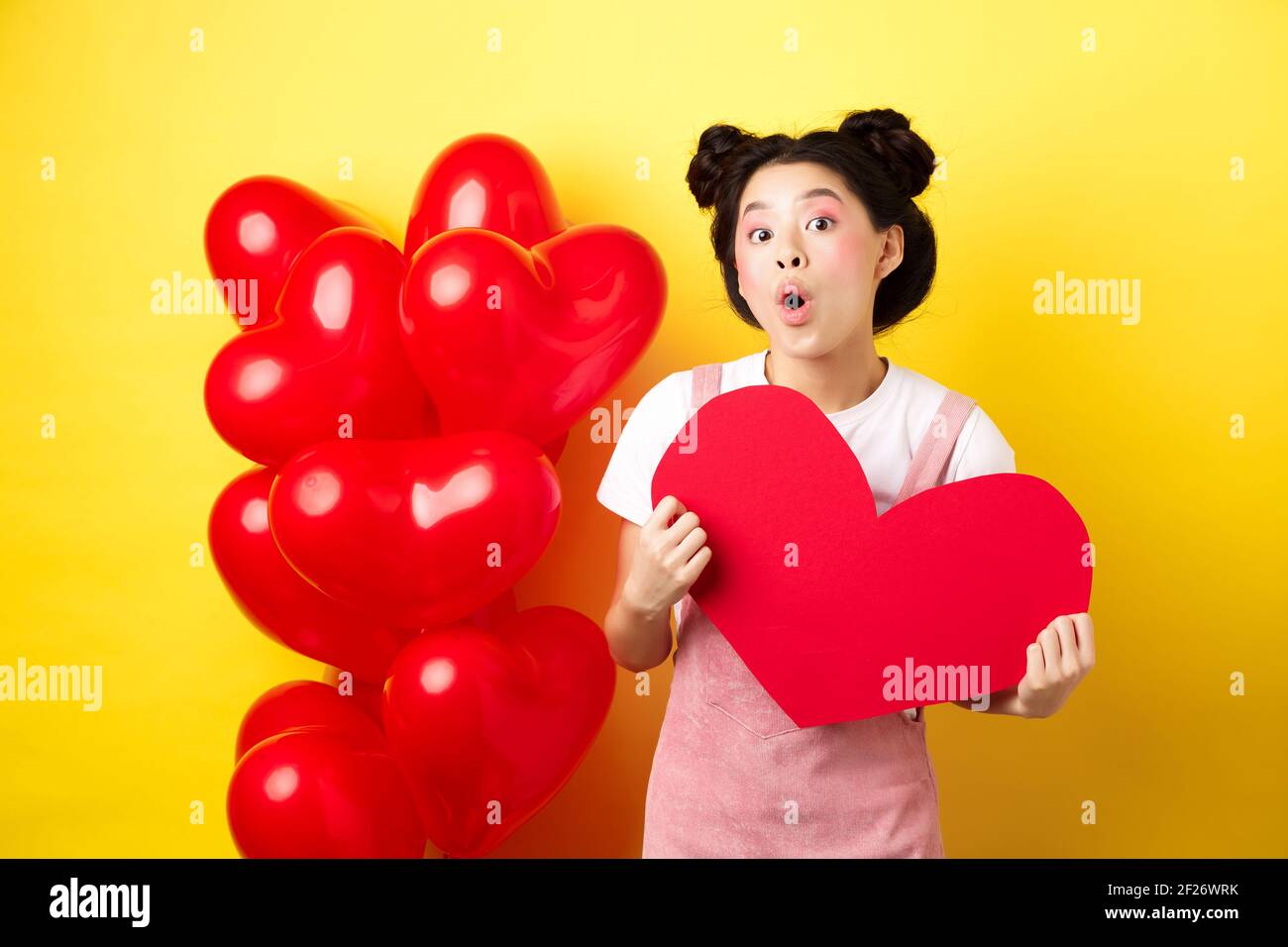 Happy Valentines day. Silly asian girl showing big red heart postcard ...
