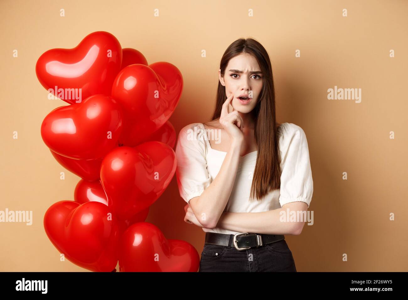 Valentines day and love concept. Confused and shocked girl staring ...