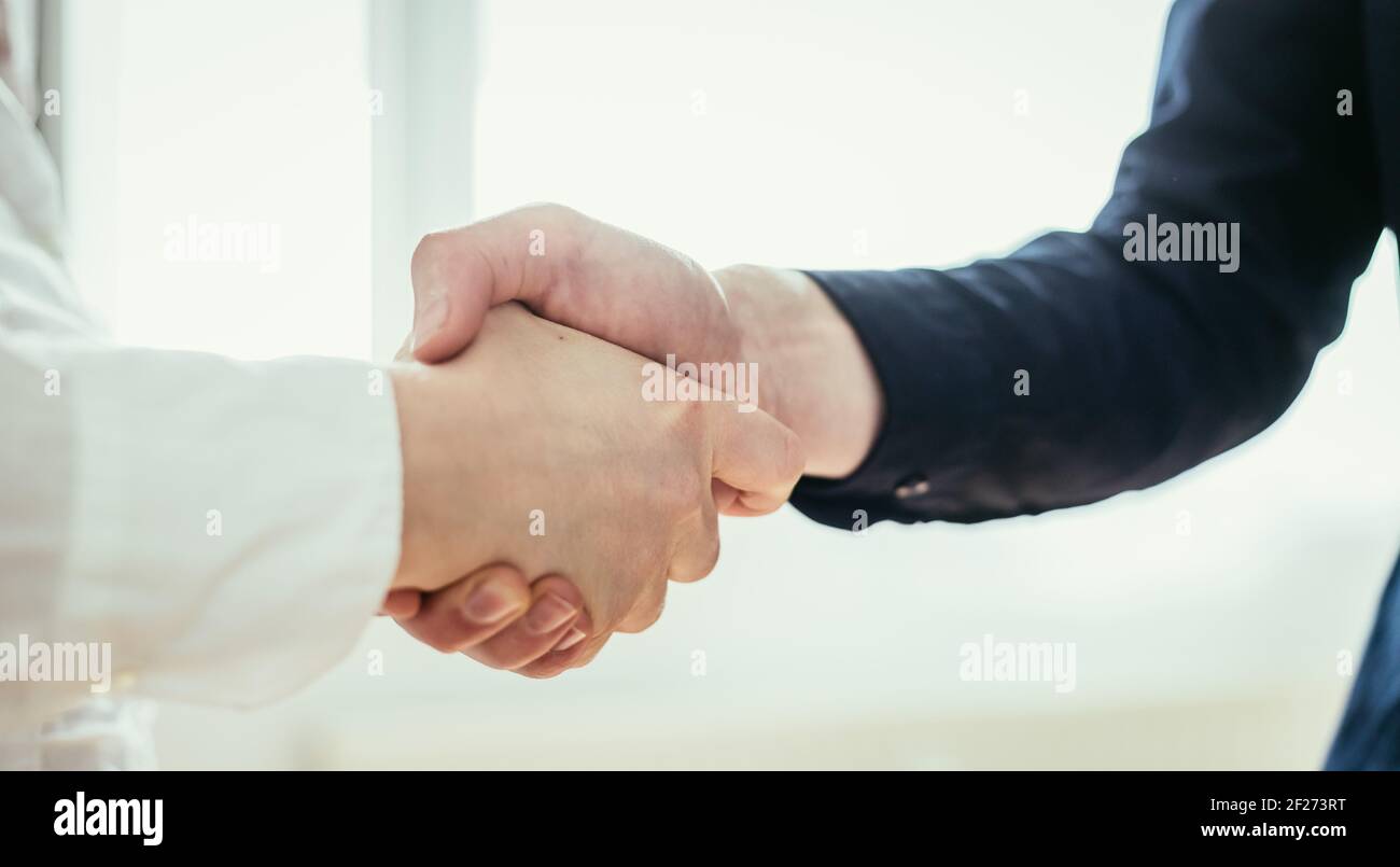 Shaking hands, concept for teamwork: Close up of man and woman shaking ...