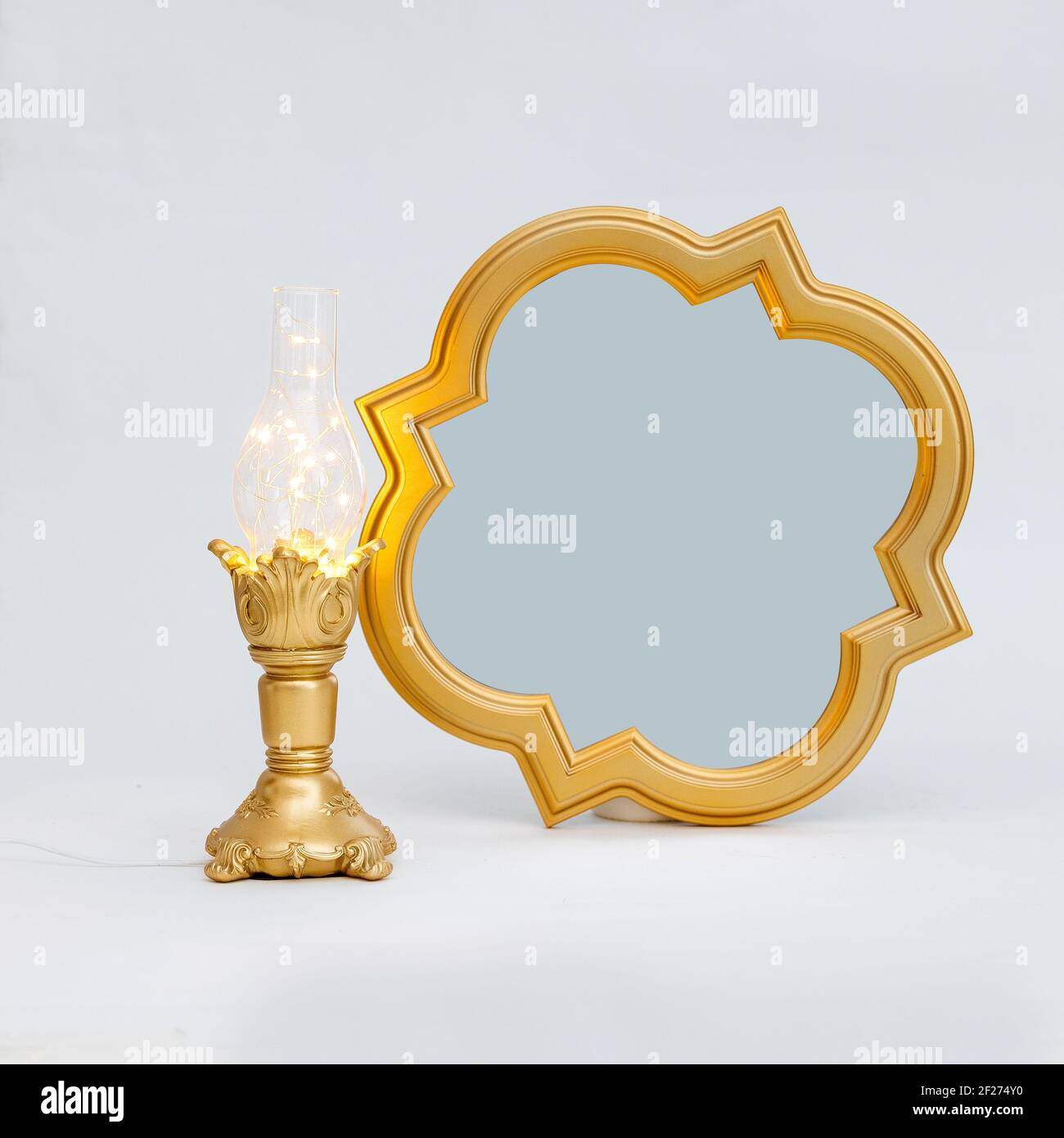 An oil lamp and a mirror with golden frames on a white background Stock ...