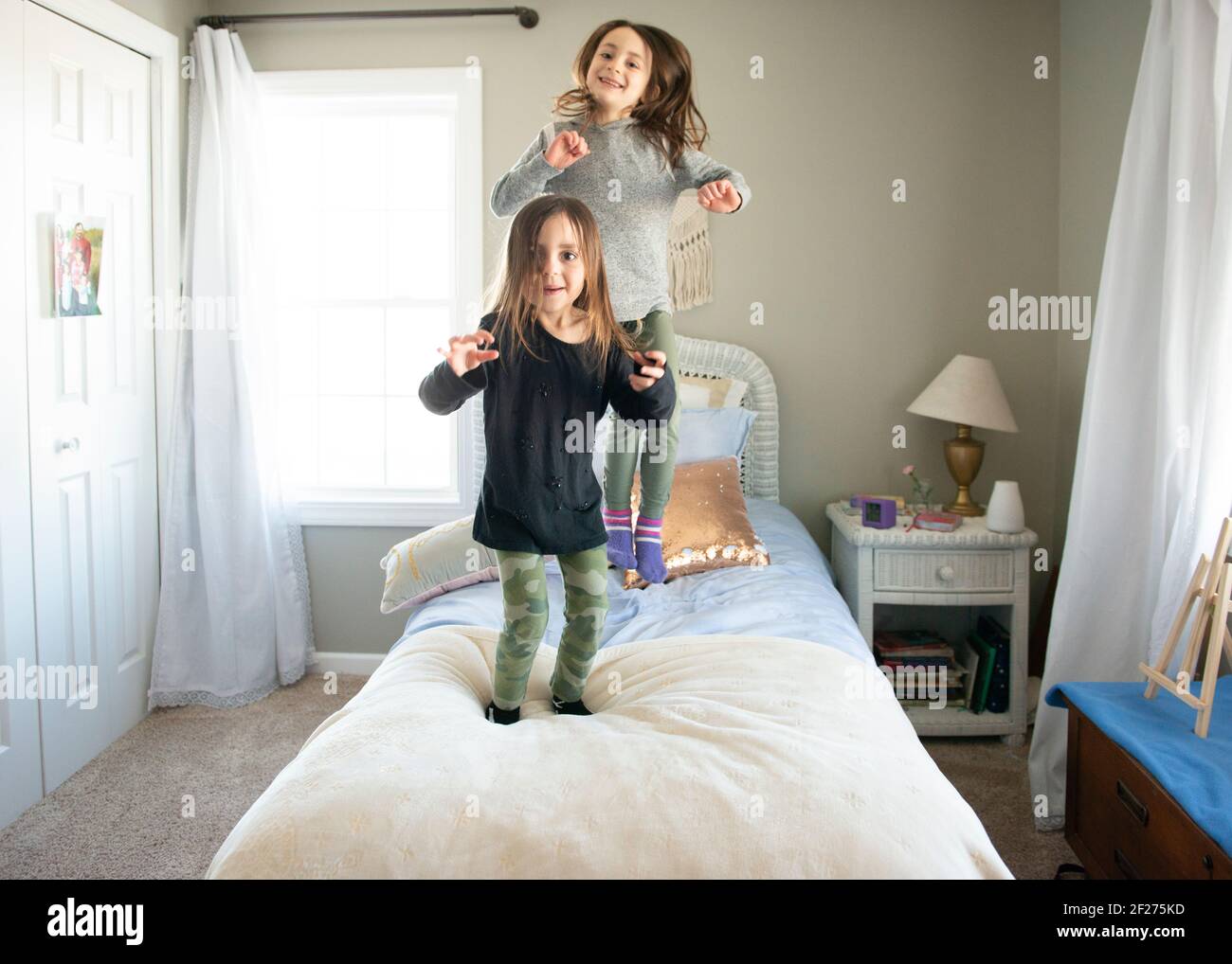 Two girls jumping on bed hi-res stock photography and images - Alamy