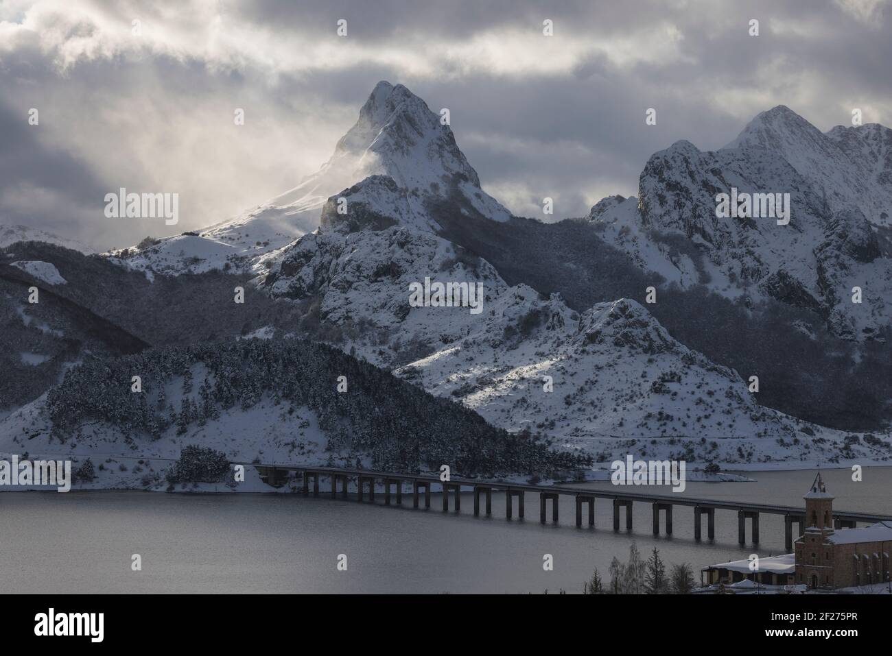 snowy high mountain over full reservoir Stock Photo - Alamy