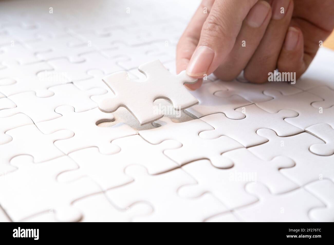 Close up hand holding puzzle price Stock Photo - Alamy