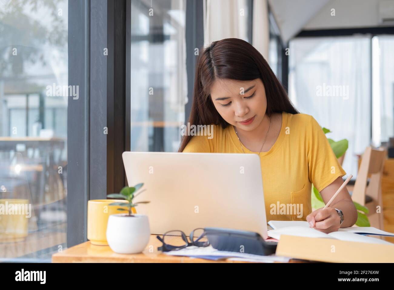 Young collage student using computer and mobile device studying Stock ...