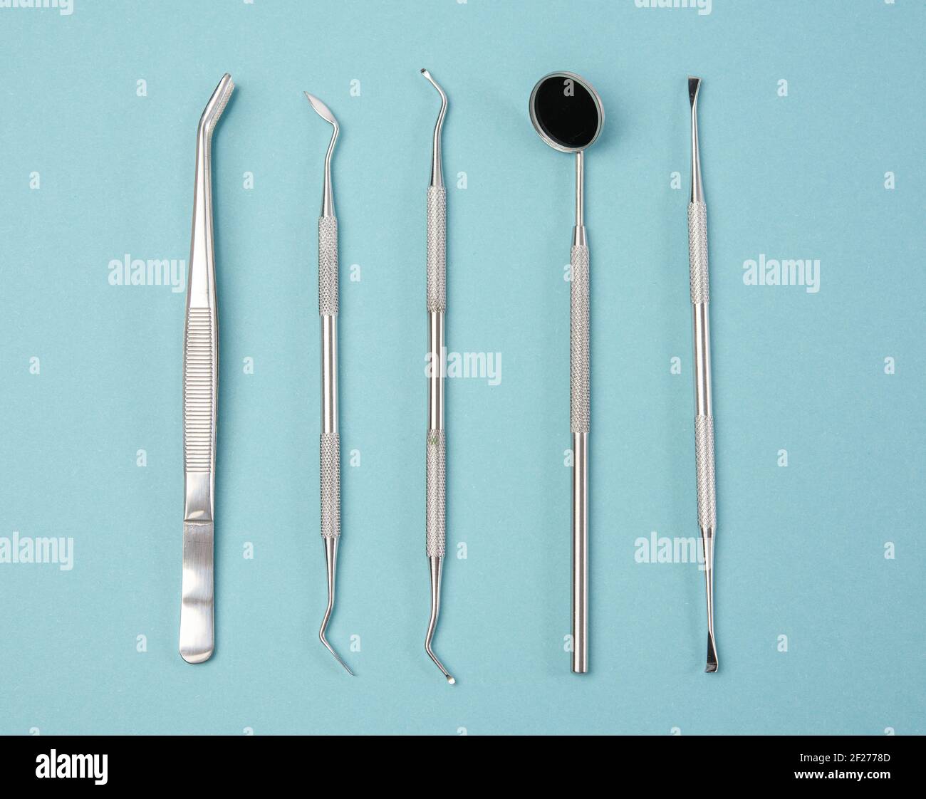 Metal medical items of the dentist on a blue background Stock Photo - Alamy