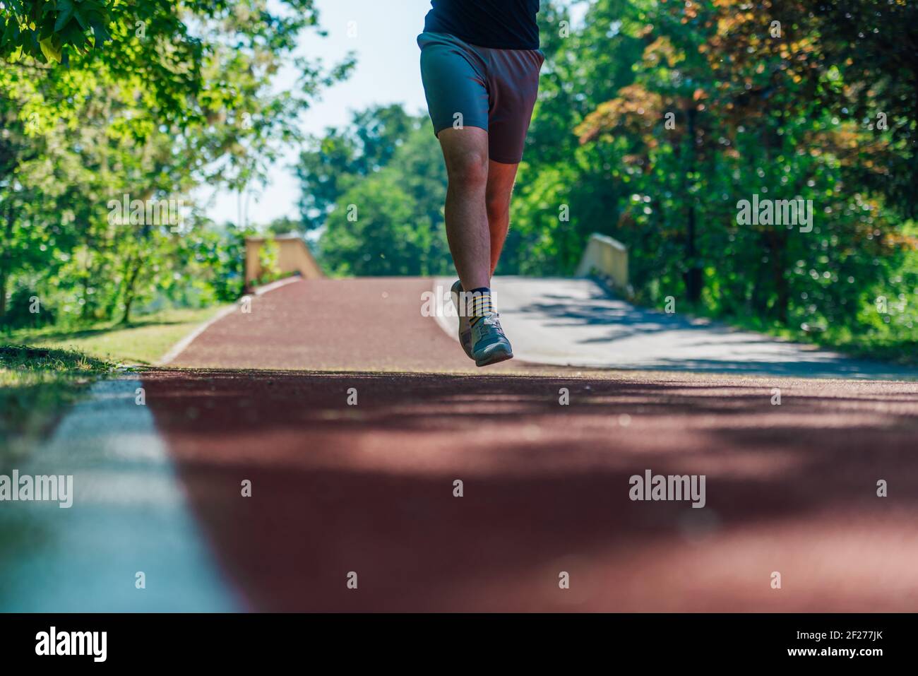 Close up feet with running shoes and strong athletic legs of sport man ...
