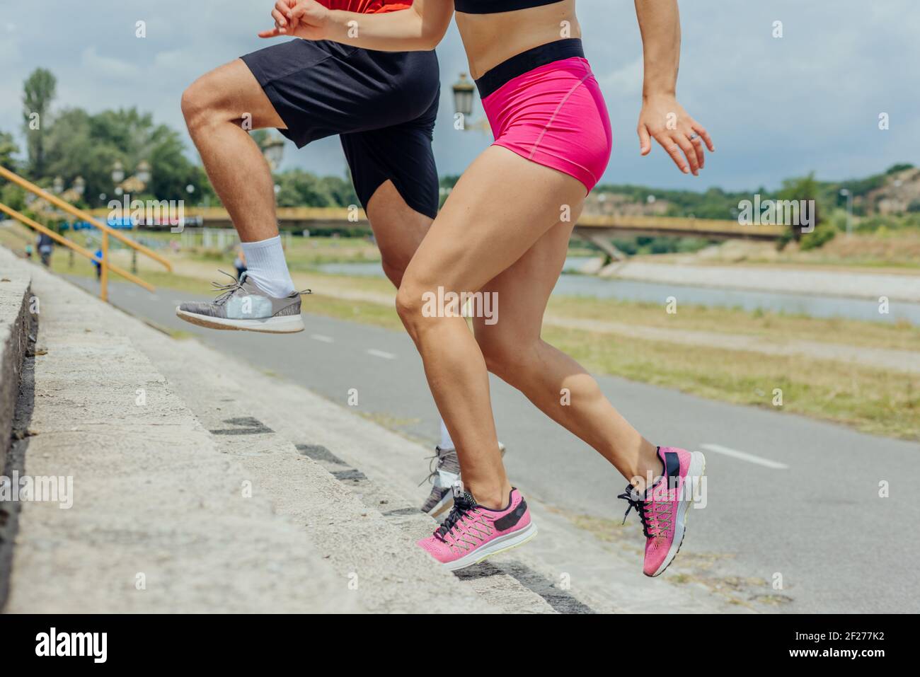 Close up side view photo of athletes legs running up concrete stairs ...