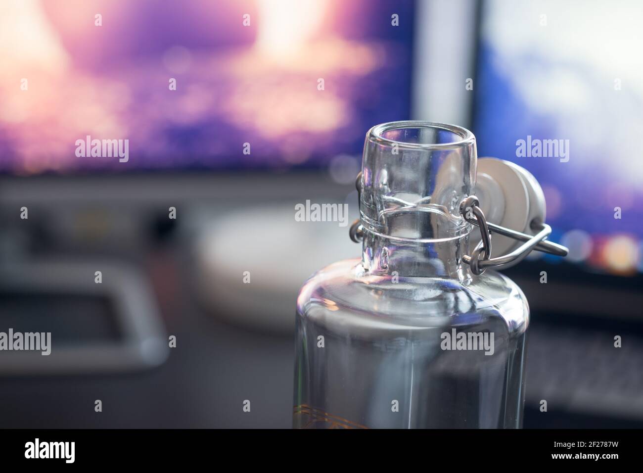 Drinking water in the office: close up of glass bottle, workplace Stock ...