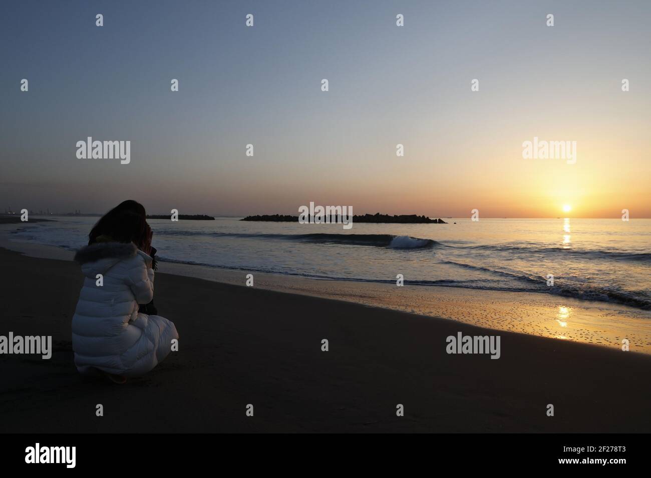 Japan. 11th Mar 2021. A woman prays at a beach in Sendai, northeastern ...