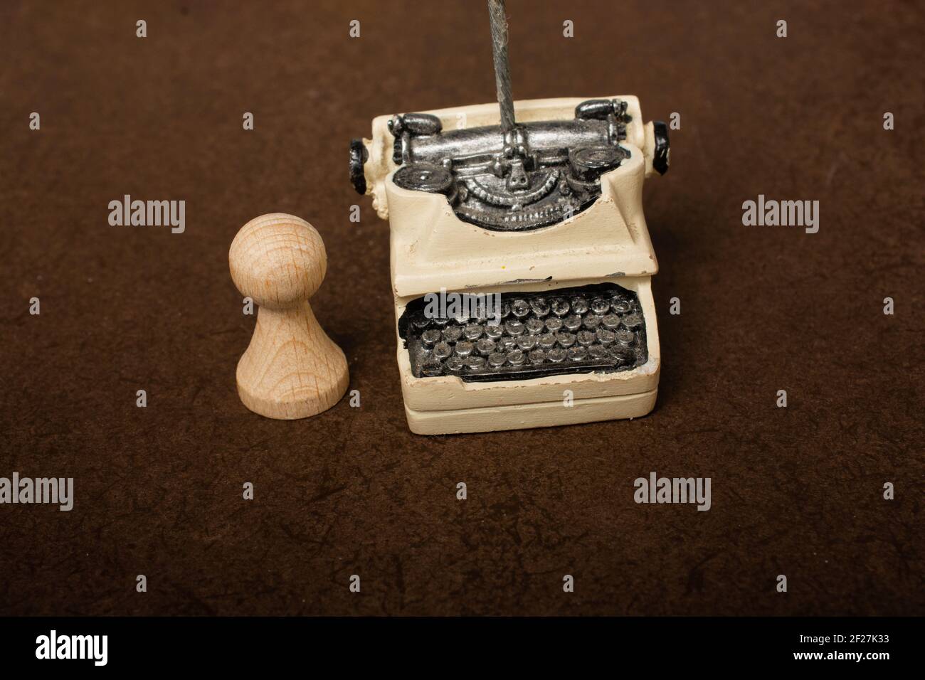 An old miniature typewriter with wooden pawn on brown surface Stock ...