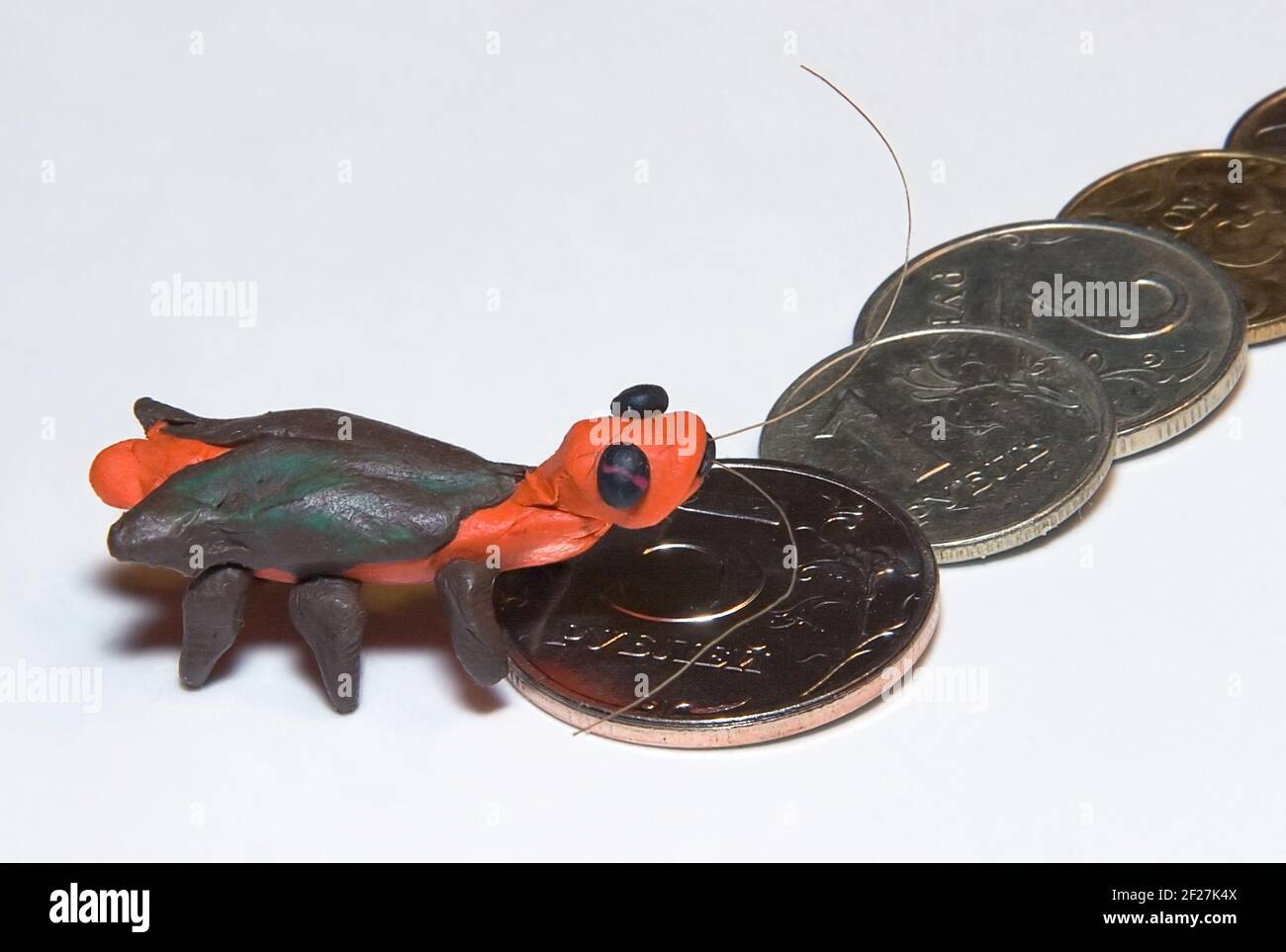 Plasticine cockroach and money on white Stock Photo - Alamy