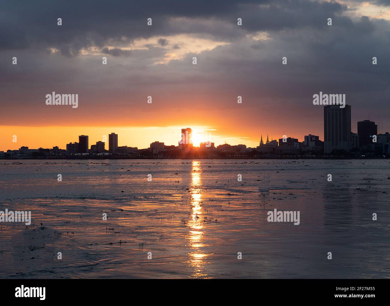 sunset in guayaquil as seen from duran with reflection of the sun on ...