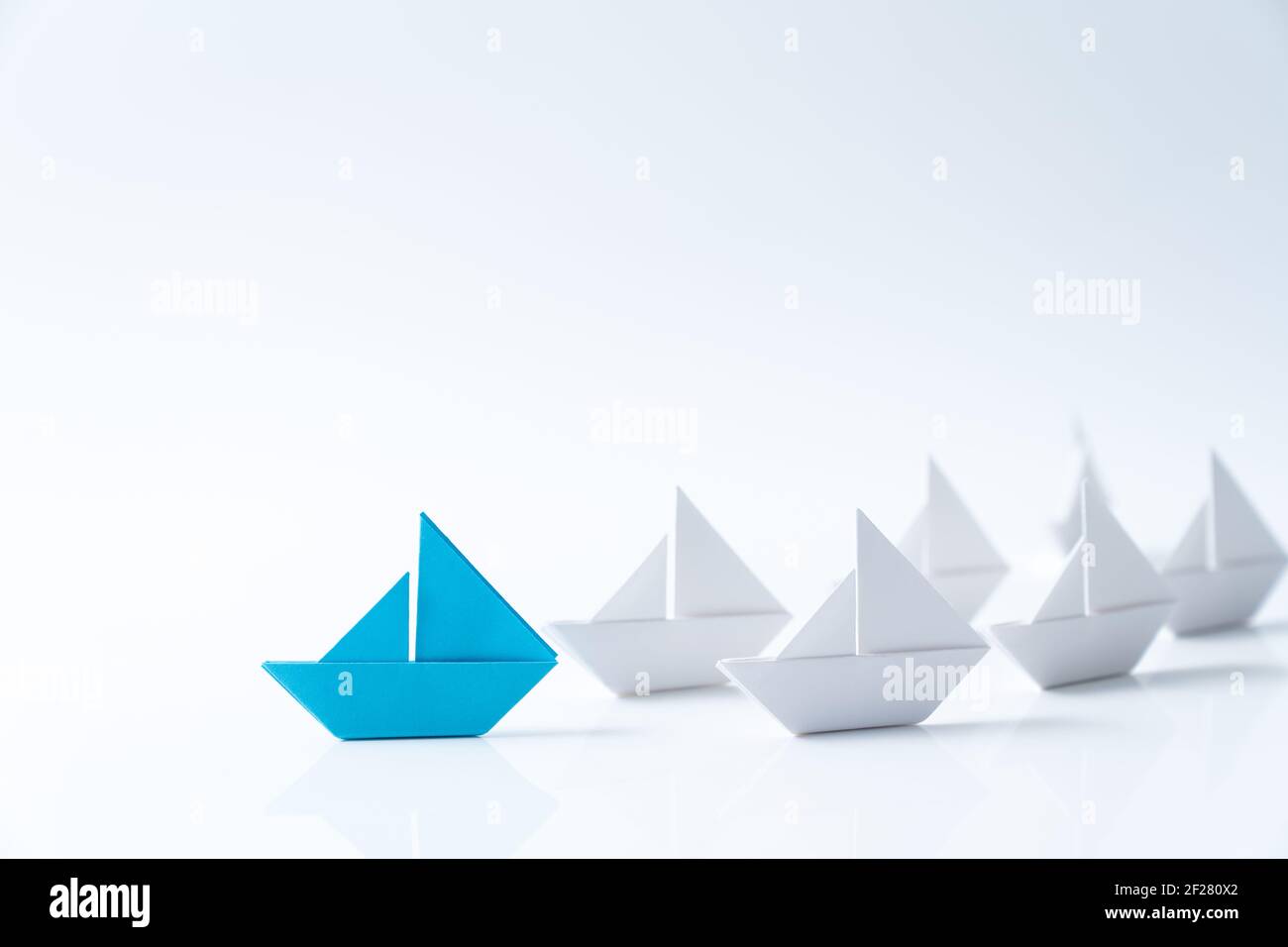 Leadership conceptual using blue paper ship Stock Photo - Alamy