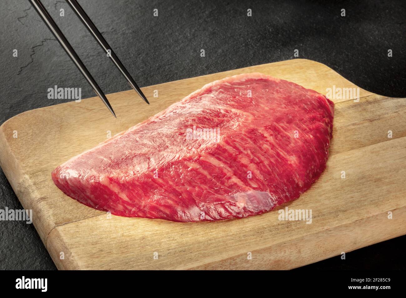 Kobe meat, wagyu beef steak, with a carving fork on a black background ...