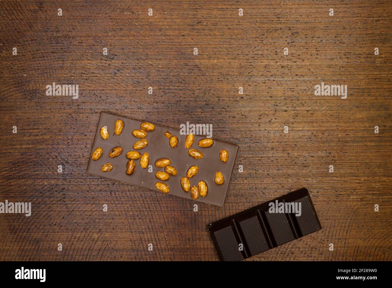 many different types of chocolate lie on a brown background with nuts ...