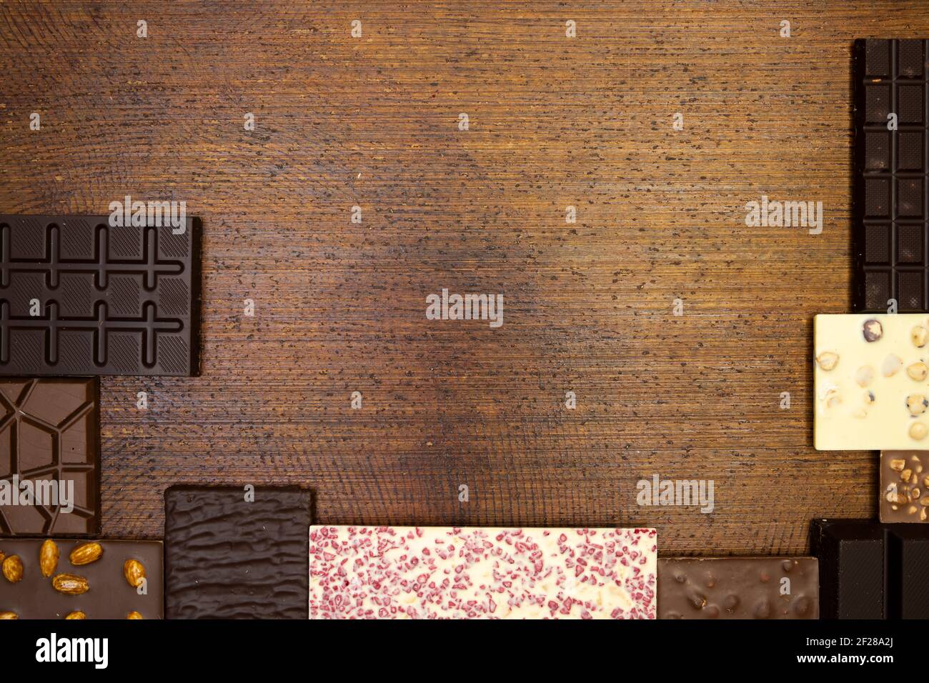 many different types of chocolate lie on a brown background with nuts ...