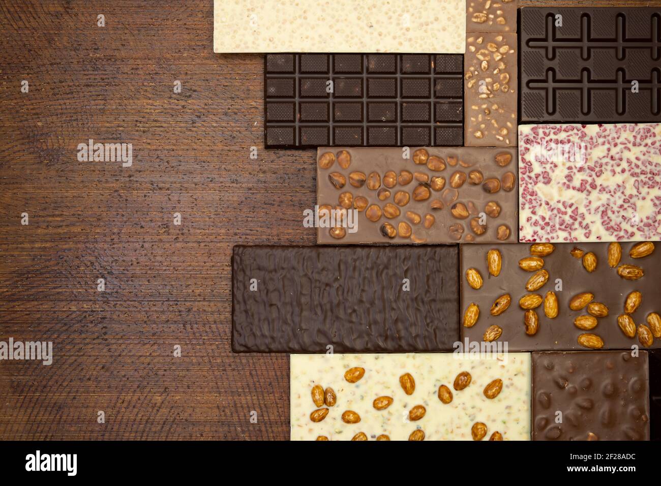 many different types of chocolate lie on a brown background with nuts ...