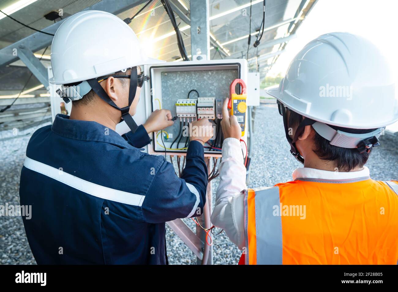Workers use clamp meter to measure the current of electrical wires ...