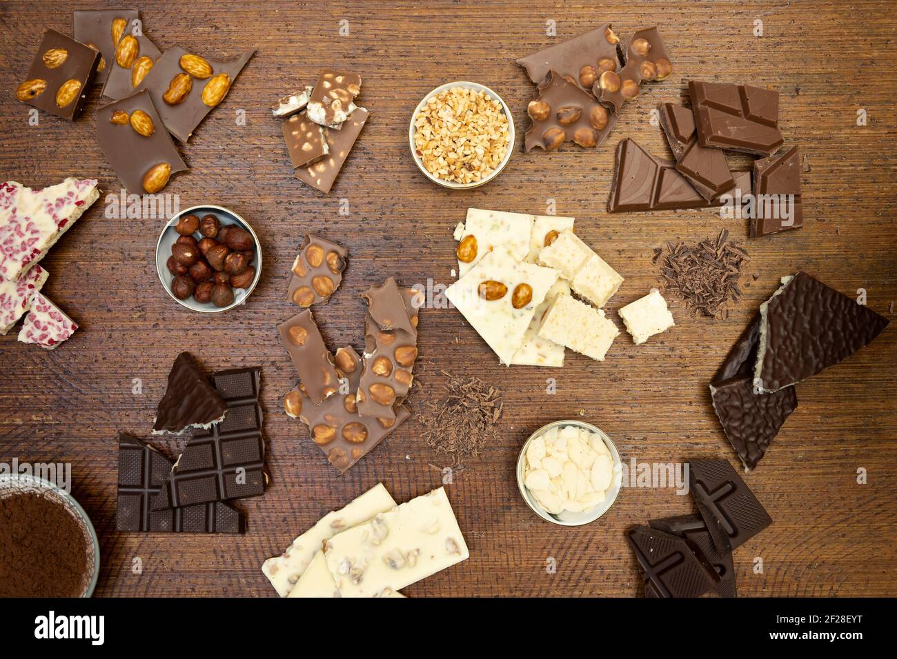 many different types of chocolate lie on a brown background with nuts ...