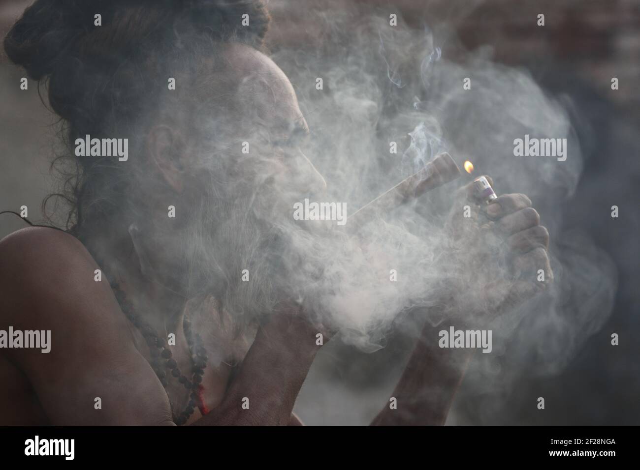 Kathmandu, NE, Nepal. 11th Mar, 2021. A Hindu sadhu smokes marijuana on ...