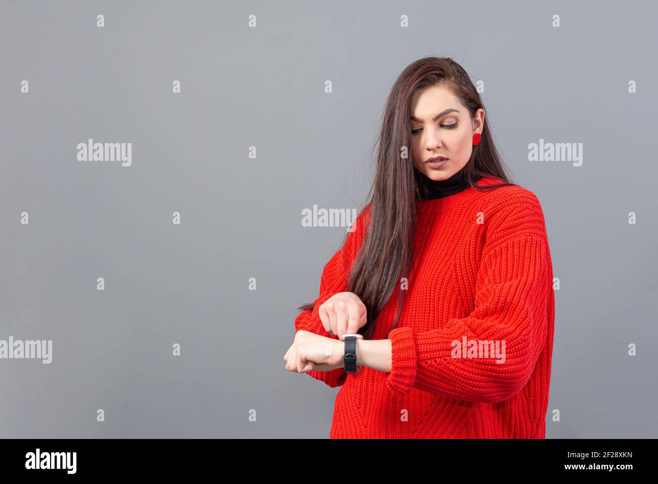 busy woman in red sweather worried looking at her wristwatch, female ...
