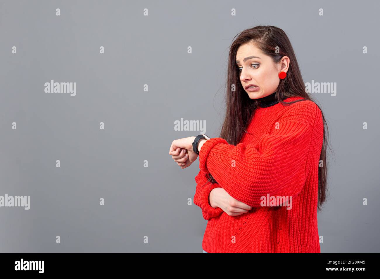 busy woman in red sweather worried looking at her wristwatch, female ...