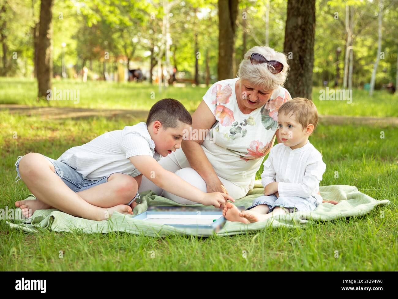 Grandma and grandchildren playing together. Two generations of family ...