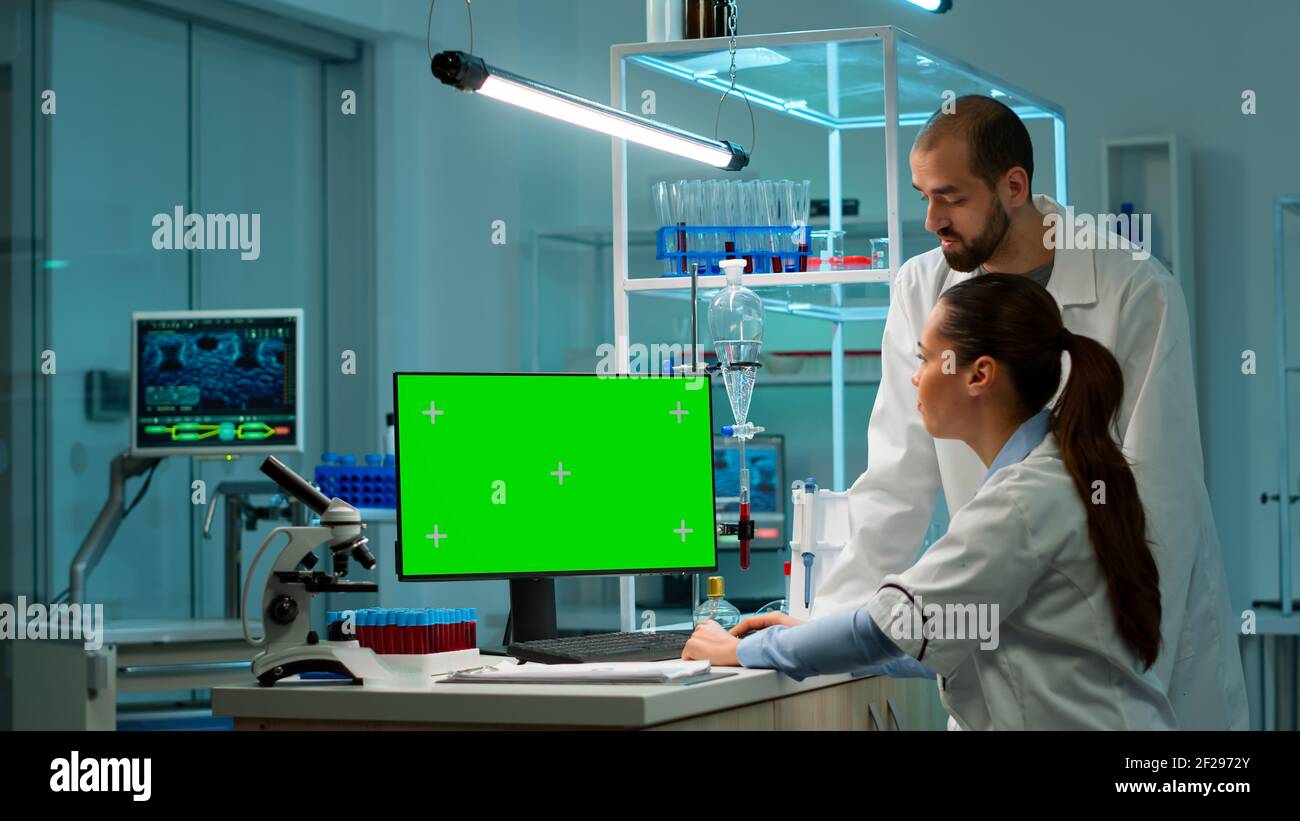 Female research scientist has conversation with man bioengineer next to ...
