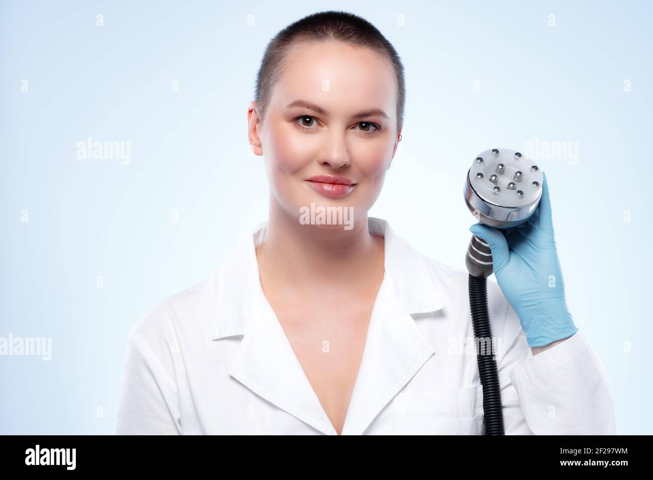 Portrait of a woman dermatologist holding cosmetic device attachment ...