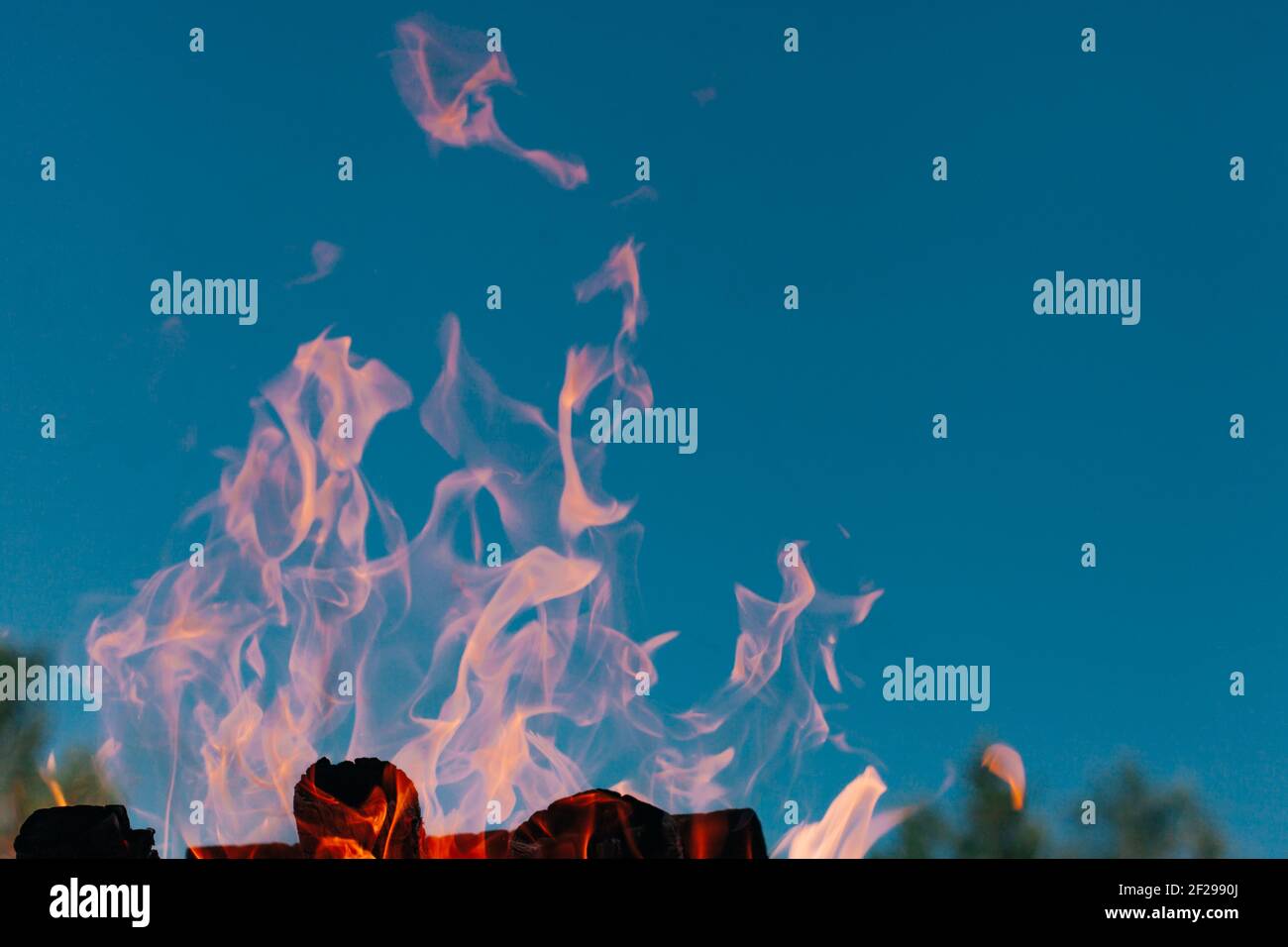 Bonfire outside, orange flames on blue skye Stock Photo - Alamy
