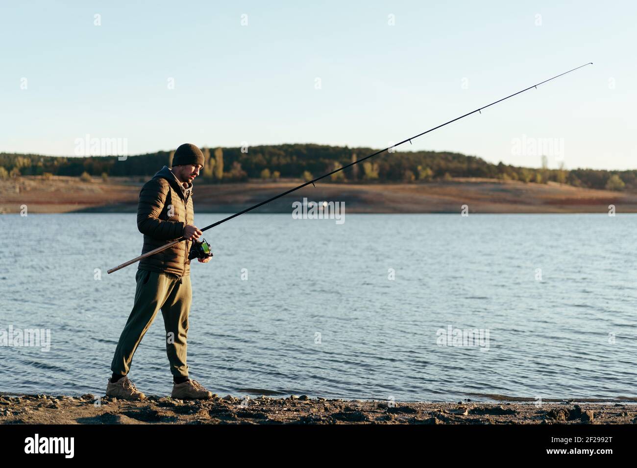Fisherman with rod fishing on the lake Stock Photo - Alamy