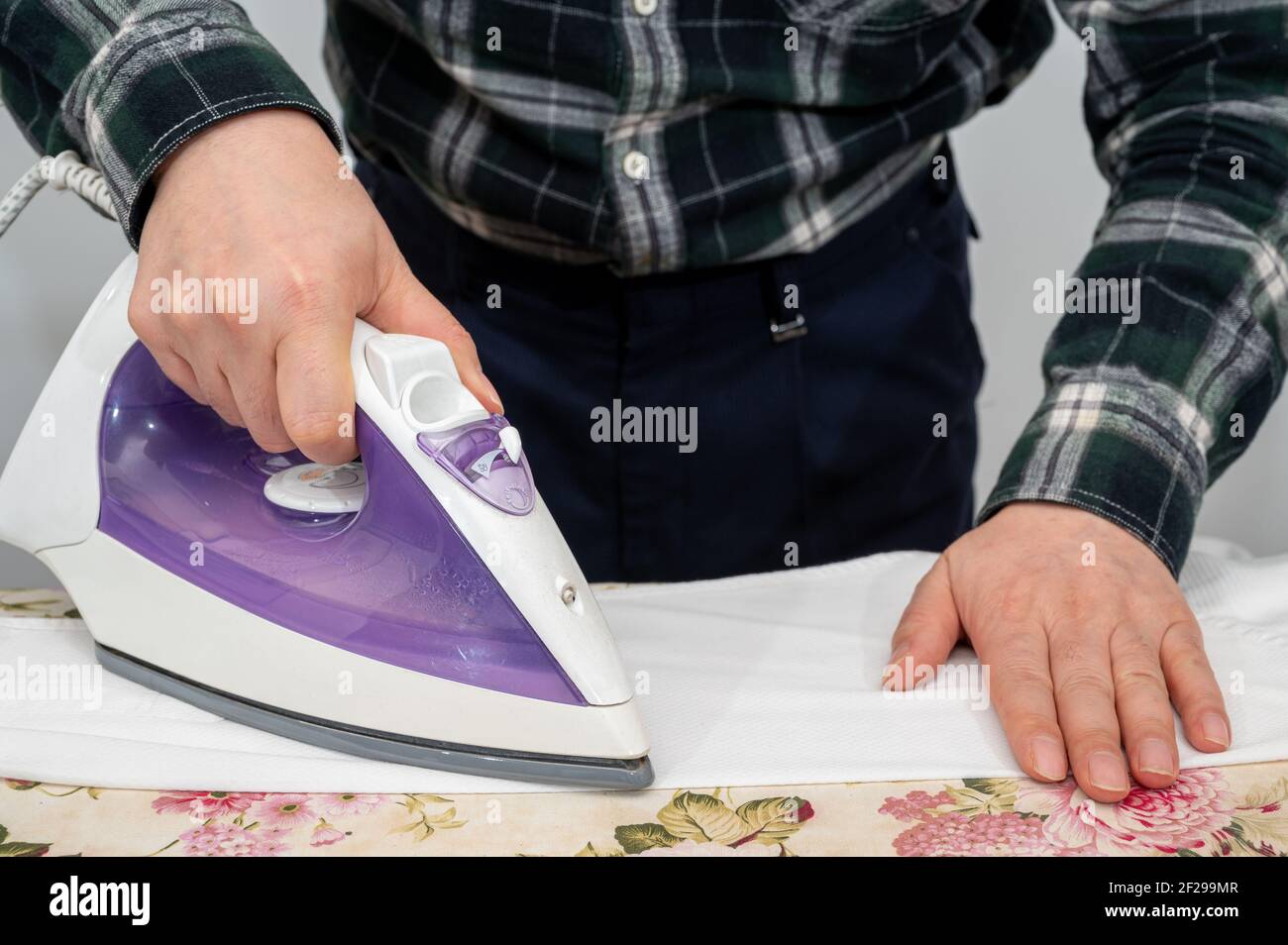 A man ironing clothes on an ironing board Stock Photo - Alamy