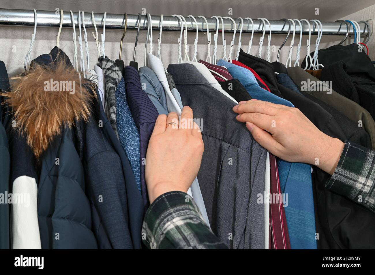 Various clothes hanging on hangers and filling the closet Stock Photo ...