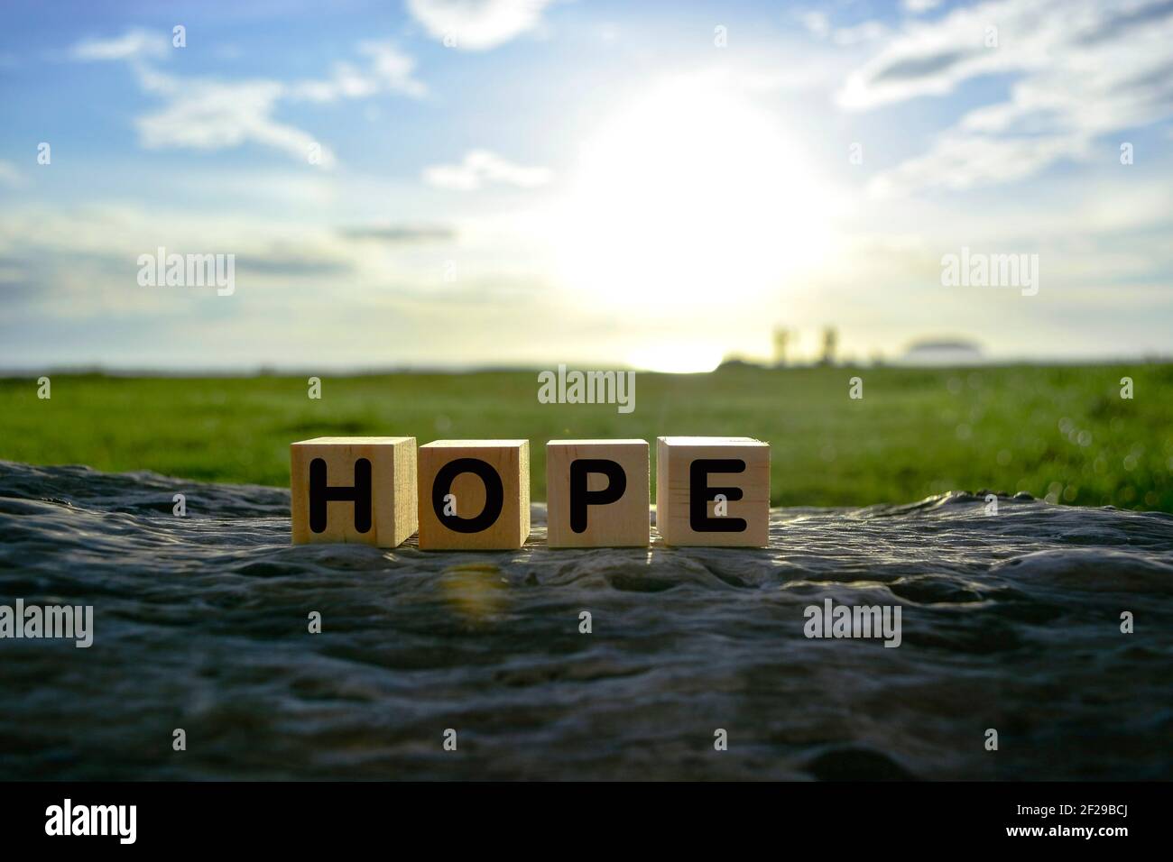 Hope text on wooden cube block on old tree stump with blurred ...