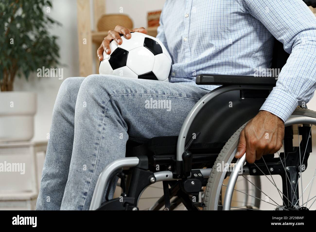 Invalid or disabled man sitting on wheelchair and holding soccer ball ...