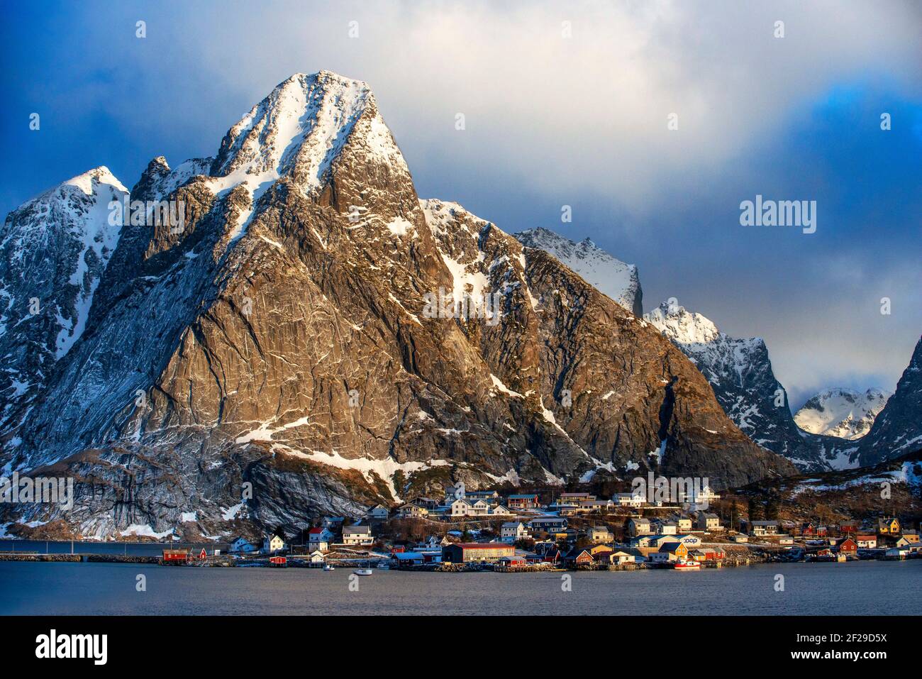 View across the natural fishing harbour to towering mountains above ...